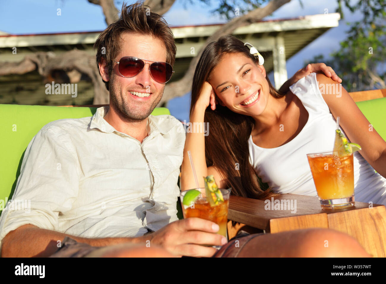 Couple Drinking Alcohol At Beach Club Having Fun With Alcoholic Drink
