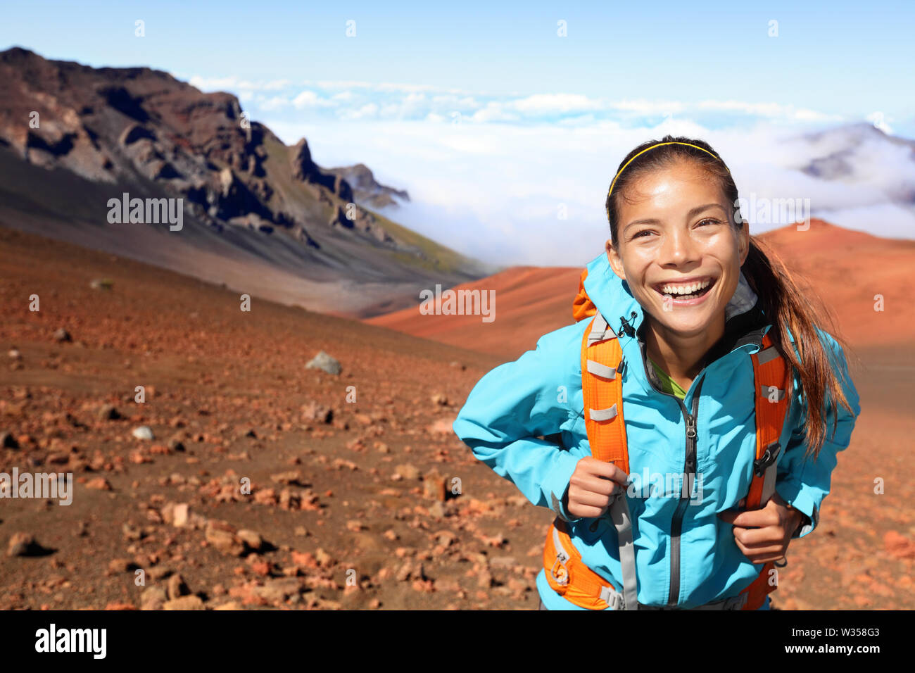 Hiking - hiker walking on volcano. Woman walking smiling happy looking ...