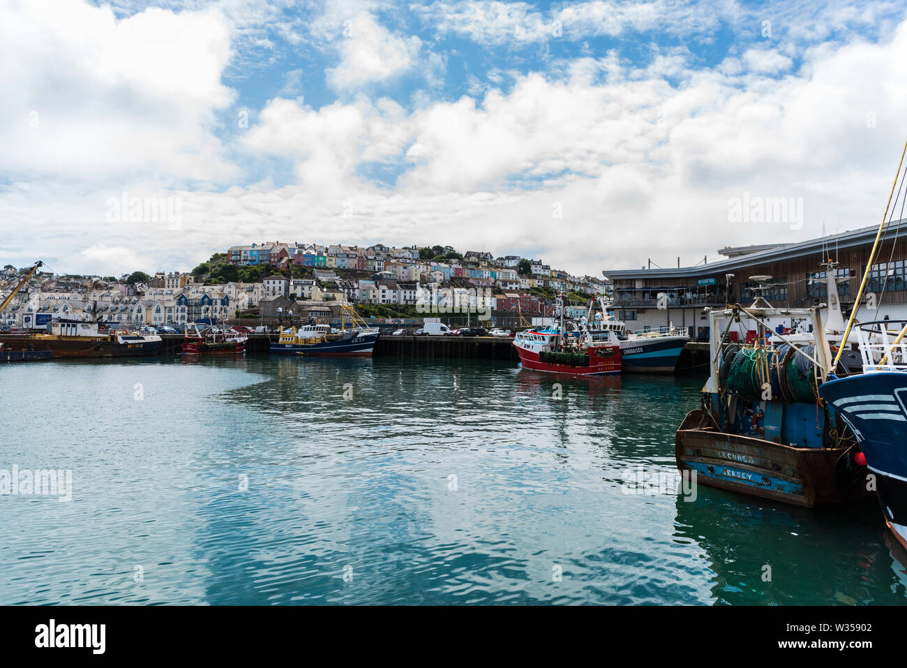 Brixham harbour, Devon, under cloudy blue skies Stock Photo - Alamy