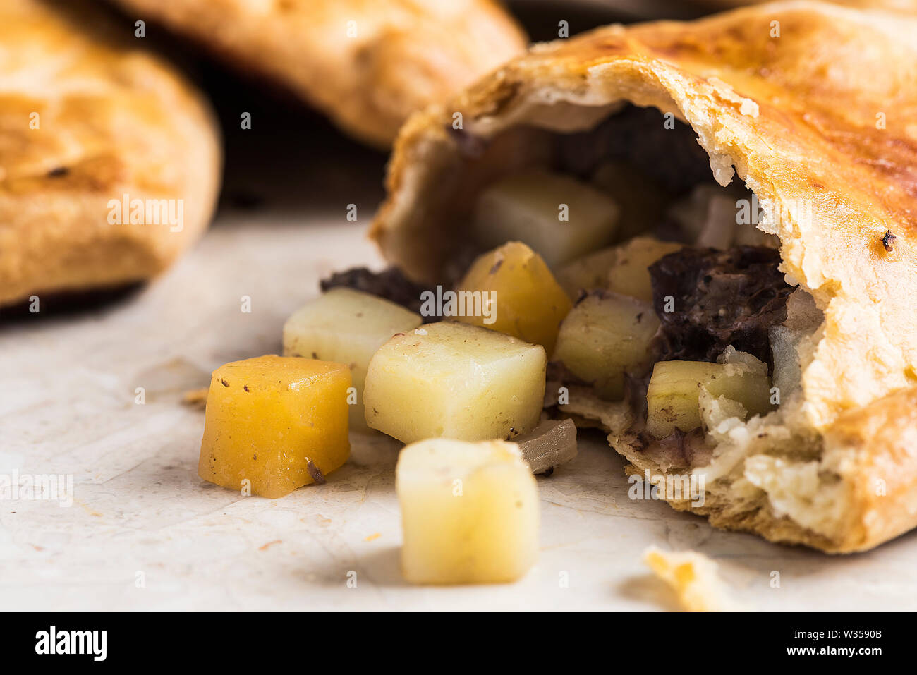 Freshly baked pasty, broken open and showing the filling Stock Photo ...