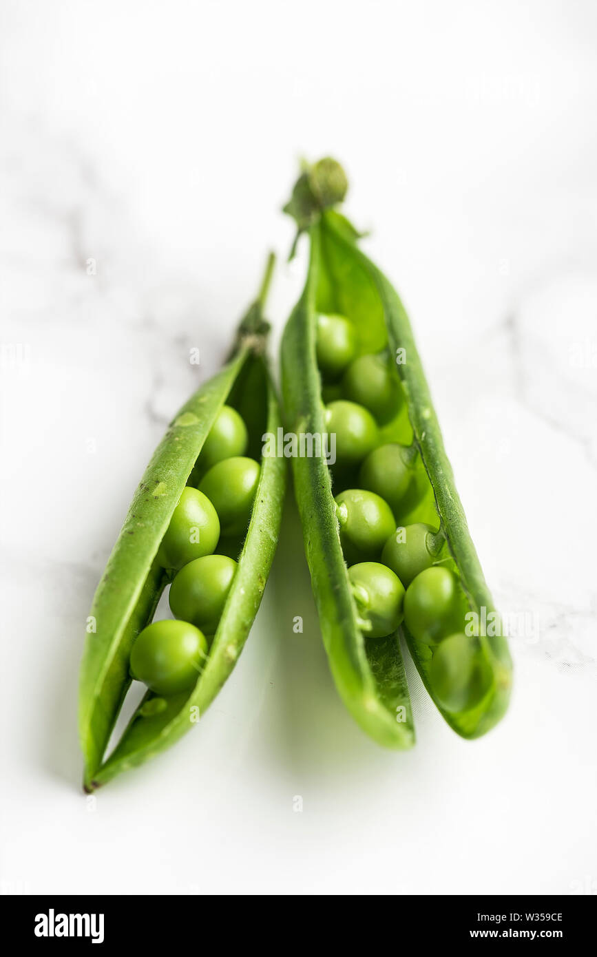 Fresh garden peas in their pods on a marble surface Stock Photo - Alamy
