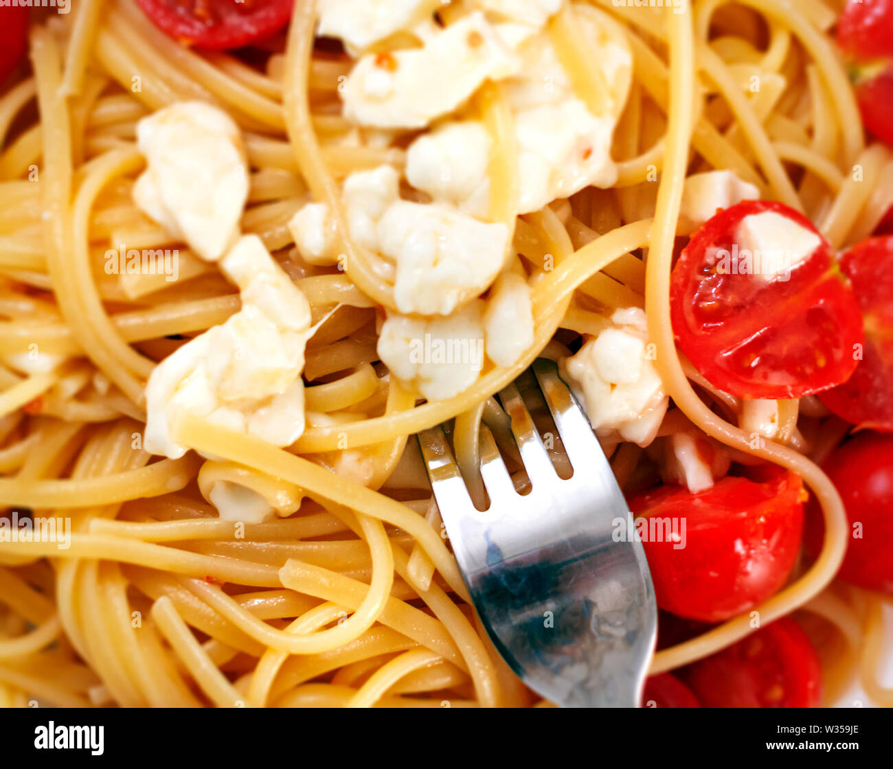 Top view of a plate of spaghetti seasoned with cherry tomatoes and ...