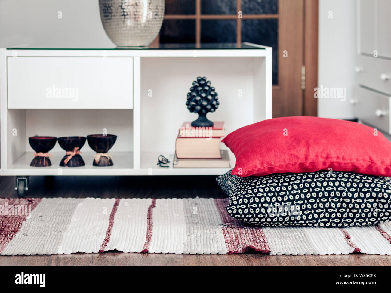 Cozy home interior decor, white nightstand with pile of books, candles ...