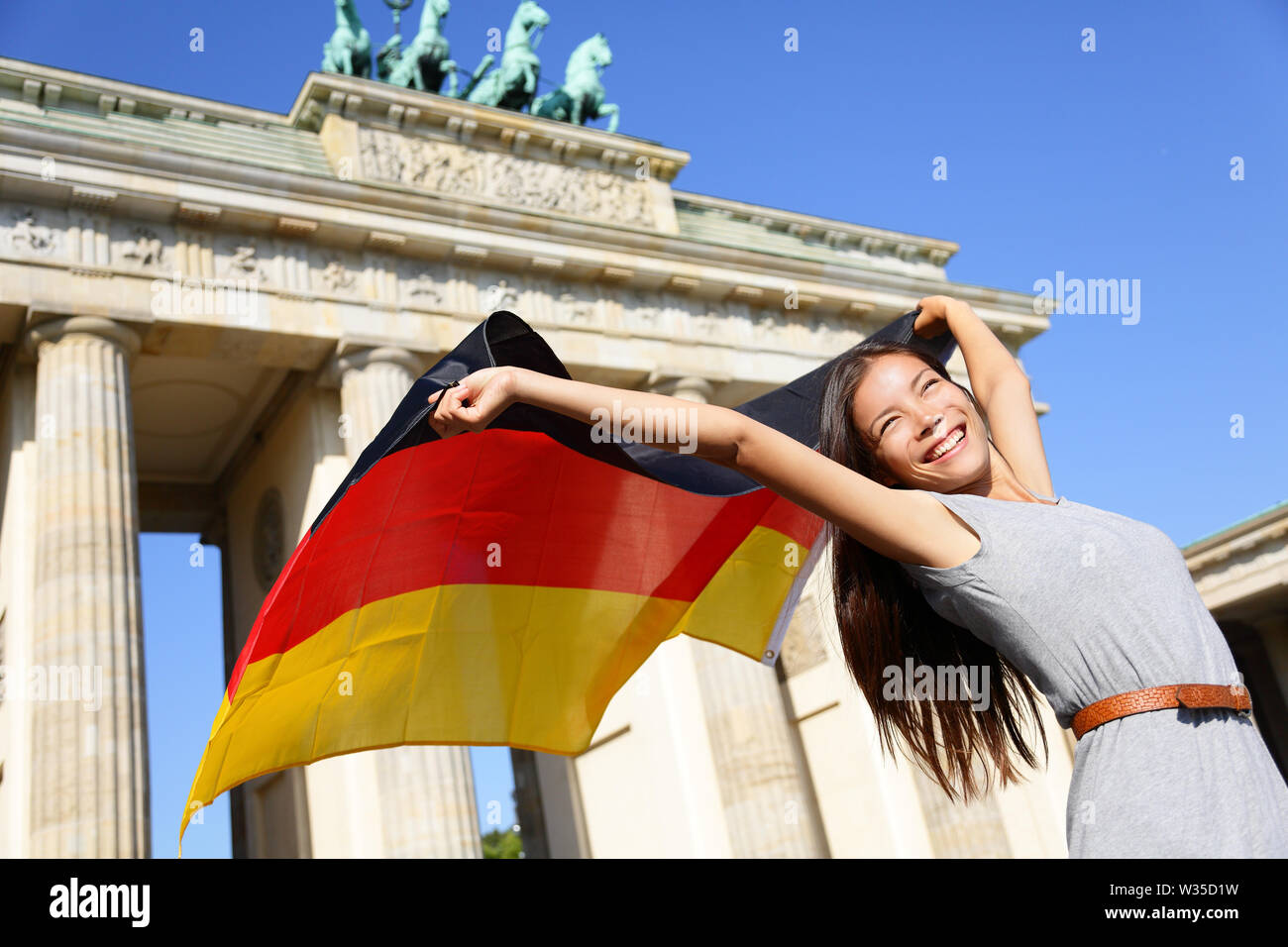 German flag - Woman happy at Berlin Brandenburg Gate cheering ...