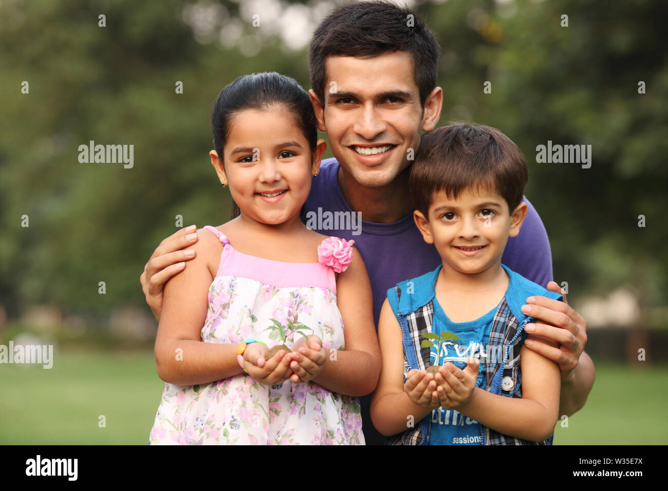 Portrait of an Indian father with his two children smiling Stock Photo ...