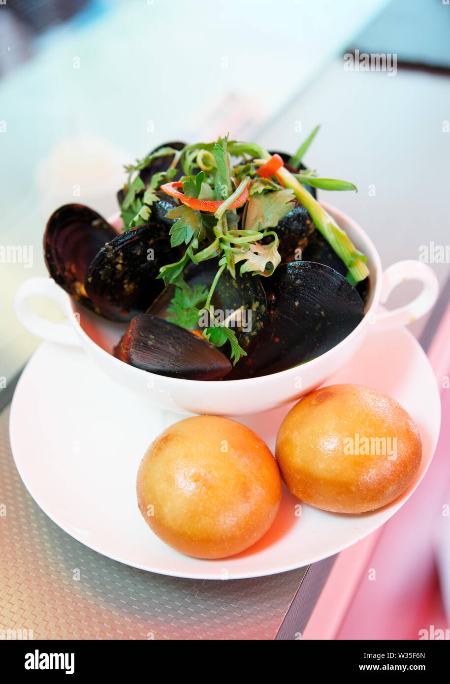 Plate of asian style cooked mussels with dim sum on takeuot restaurant ...