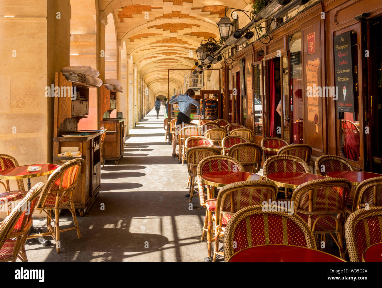 Coffee terrace with tables and chairs, under the Arches of Place des ...