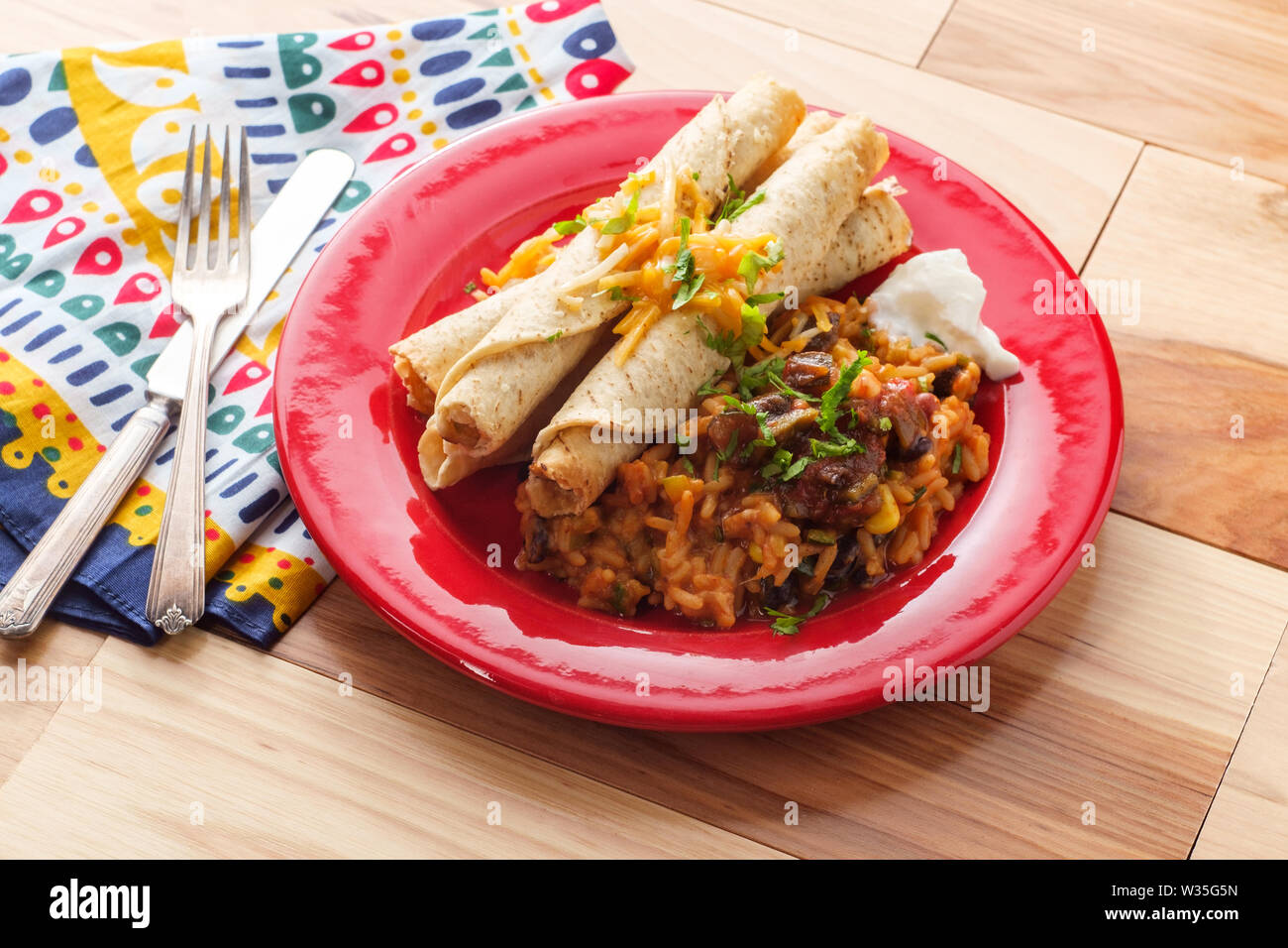 Mexican chicken and cheese taquitos with Santa Fe rice Stock Photo - Alamy