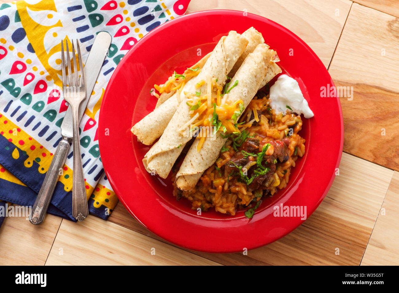 Mexican chicken and cheese taquitos with Santa Fe rice Stock Photo - Alamy