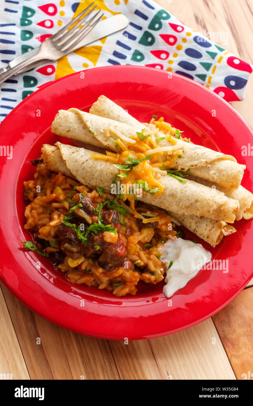 Mexican chicken and cheese taquitos with Santa Fe rice Stock Photo - Alamy