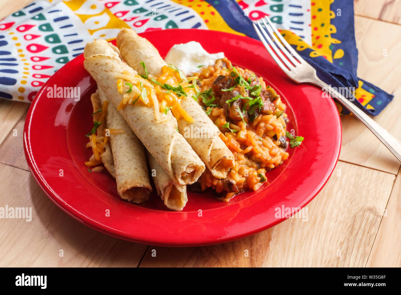 Mexican chicken and cheese taquitos with Santa Fe rice Stock Photo - Alamy