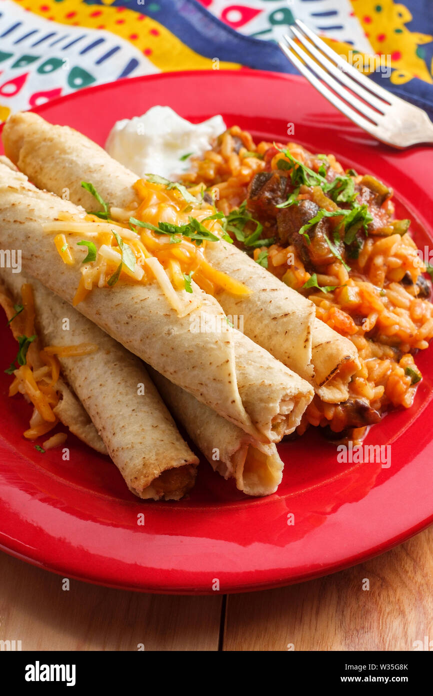 Mexican chicken and cheese taquitos with Santa Fe rice Stock Photo - Alamy