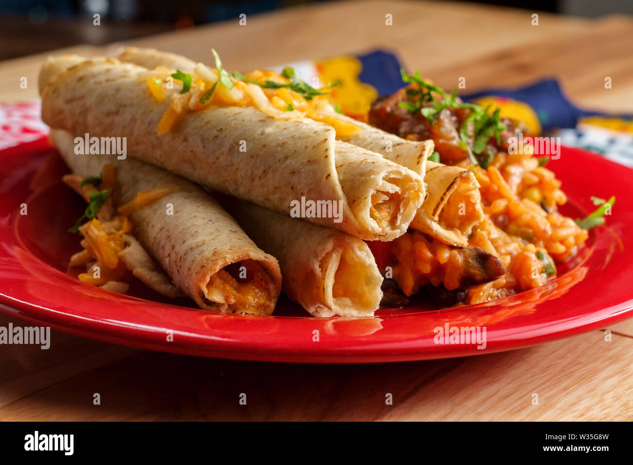 Mexican chicken and cheese taquitos with Santa Fe rice Stock Photo - Alamy