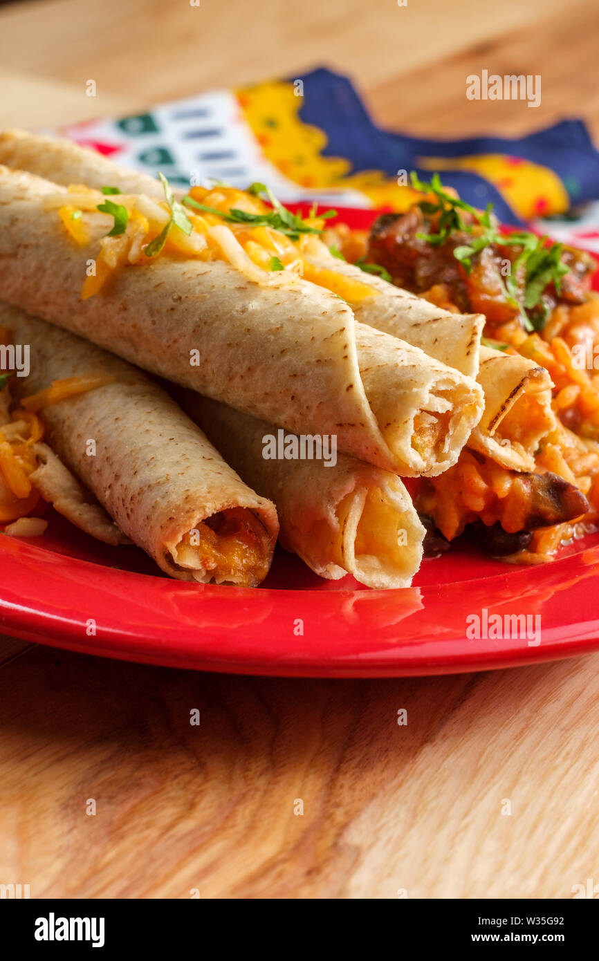 Mexican chicken and cheese taquitos with Santa Fe rice Stock Photo - Alamy