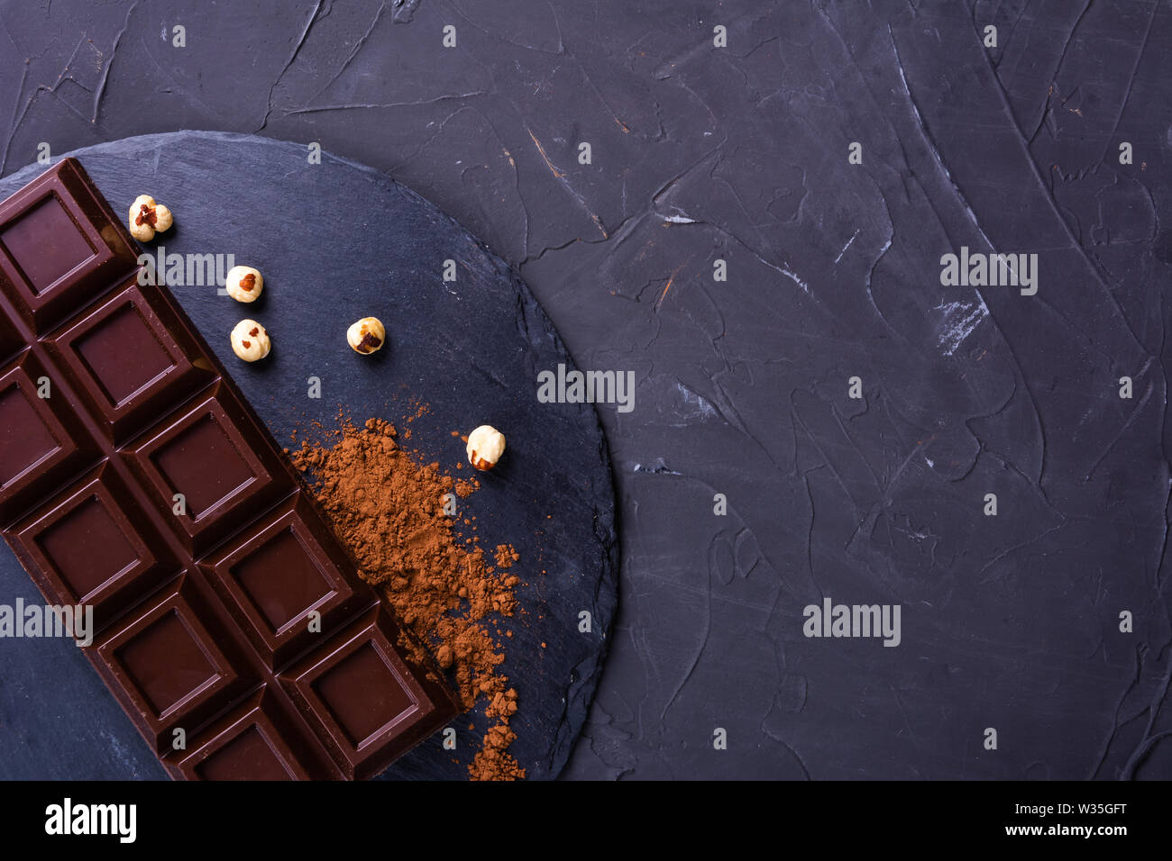 Chocolate bar with cocoas on grey background Stock Photo - Alamy