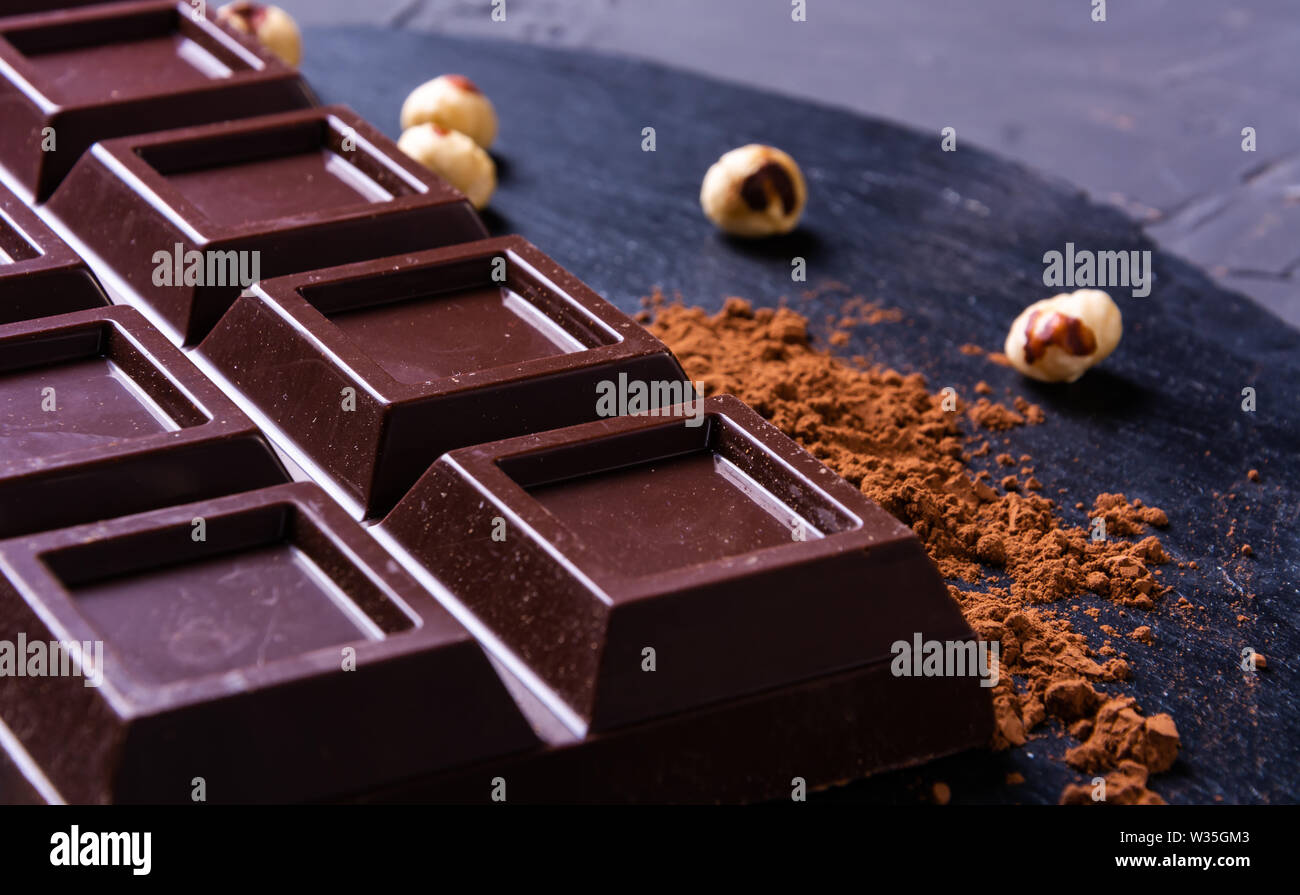 Chocolate bar with cocoas on grey background Stock Photo - Alamy