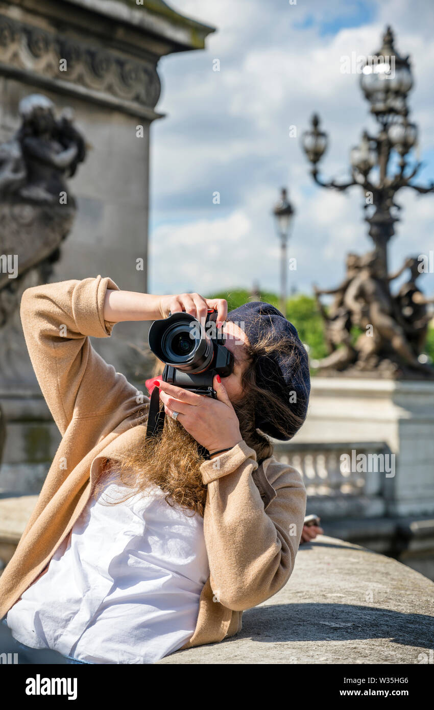 Traveling as a tourist, a young slim girl in a beret and wool cardigan ...