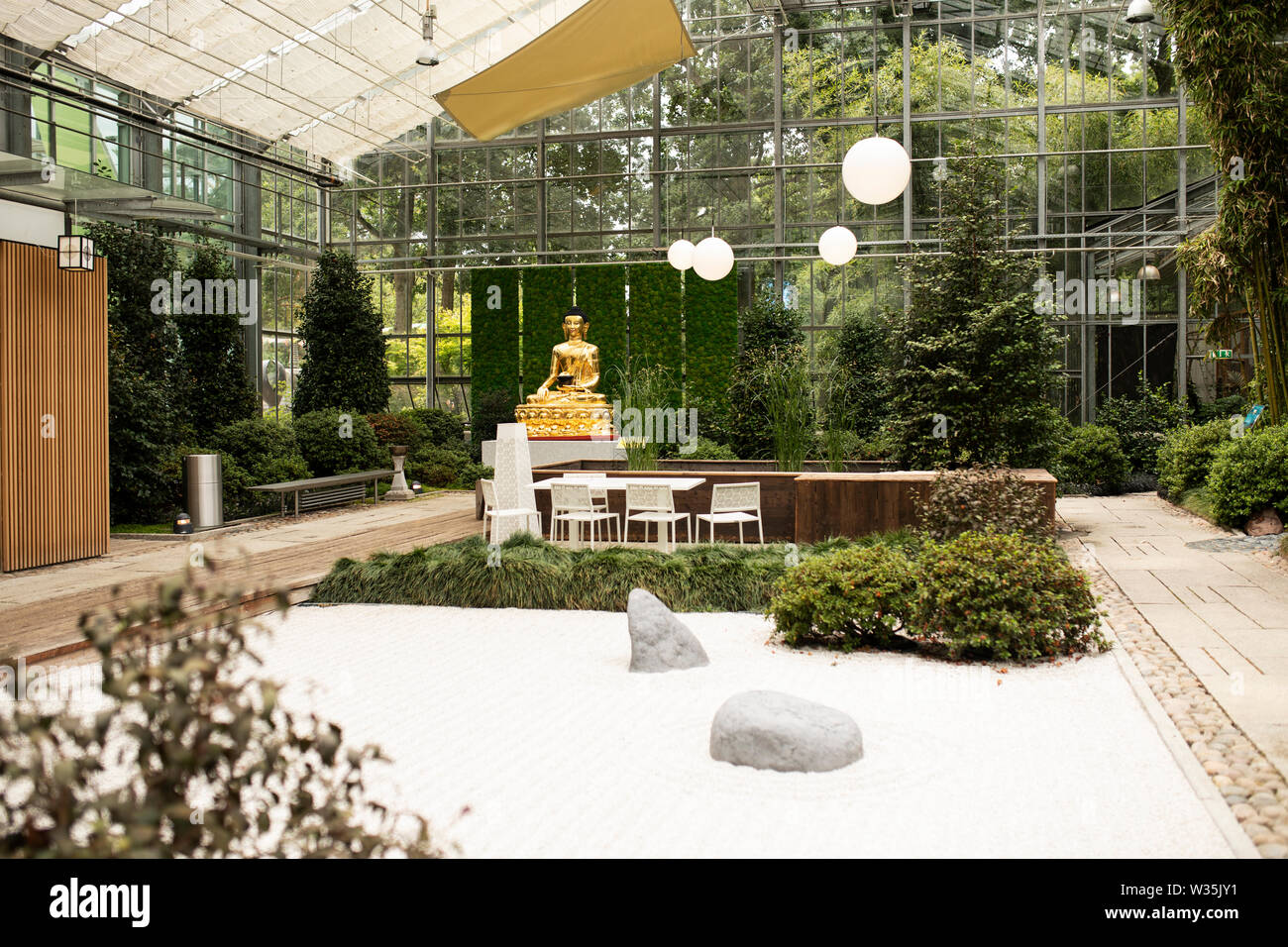The indoor Japanese garden with raked stone and Buddha statue at ...