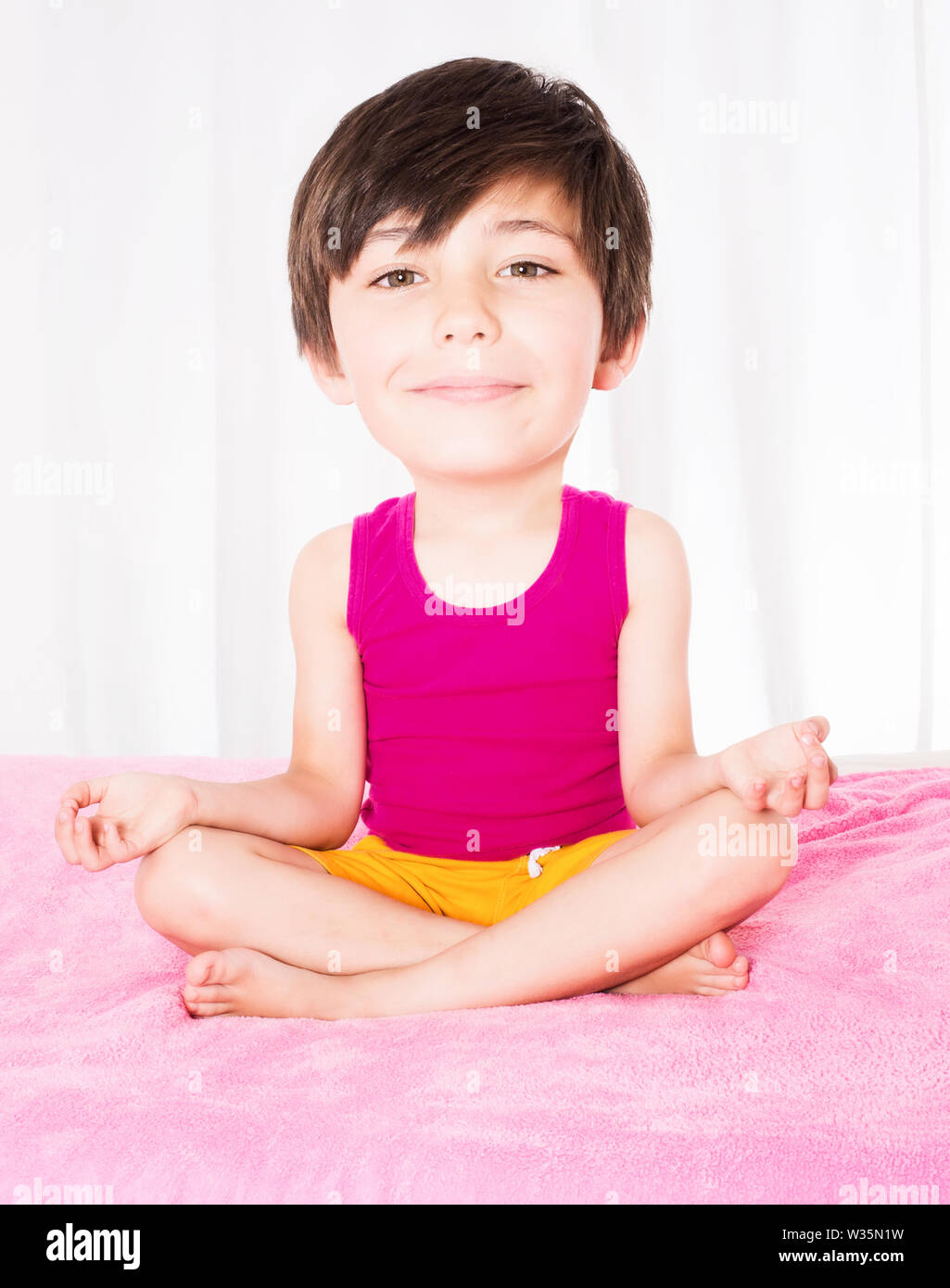 young boy with big head sitting in bed and smiling Stock Photo - Alamy