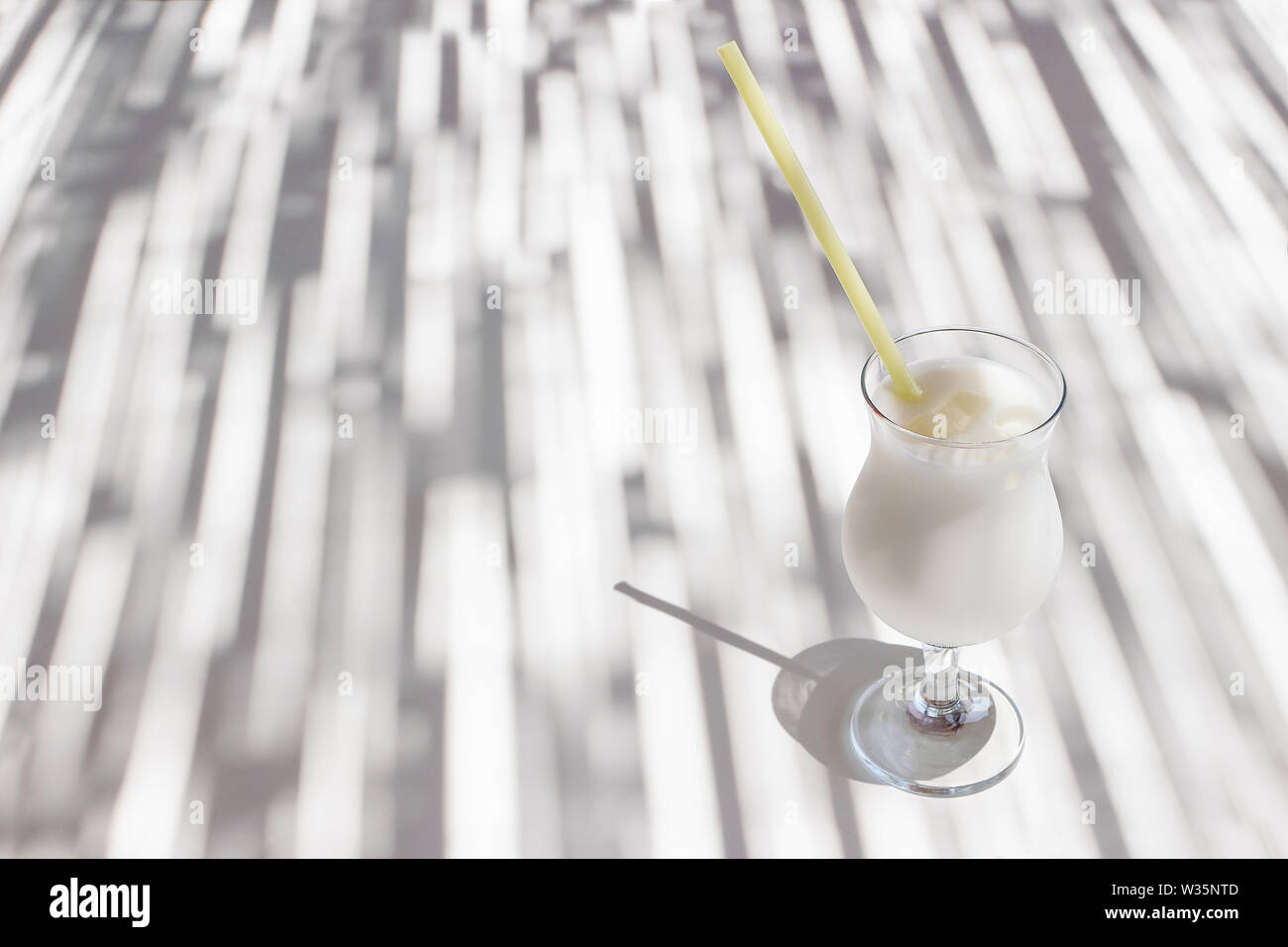 Pina colada cocktail with yellow drinking straw, coconut milk and ice ...