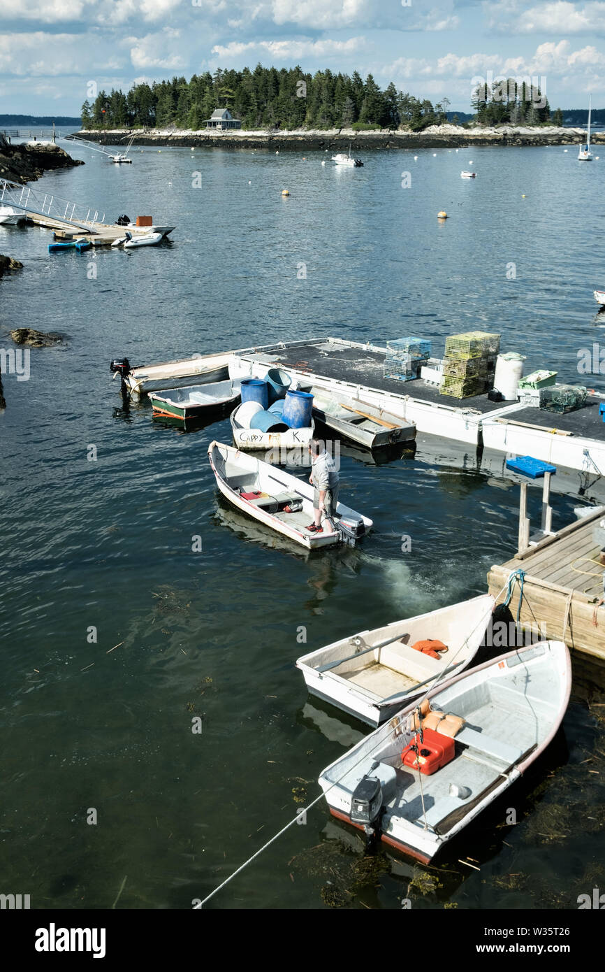 A fisherman heads out in a dinghy at Five Islands Harbor, Georgetown ...