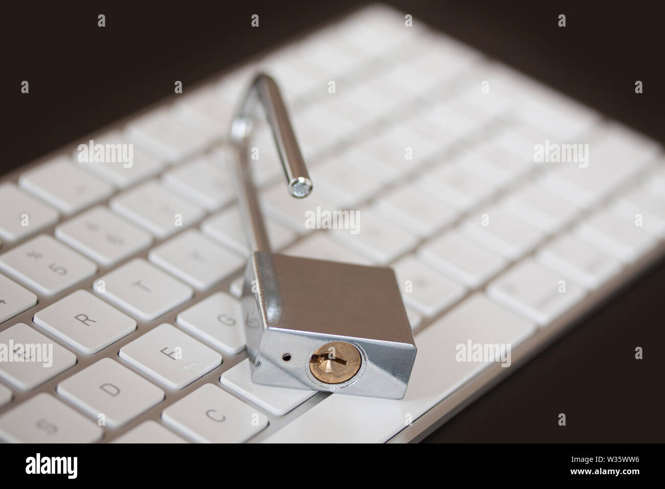 Stainless padlock on computer keyboard. PC network security, data ...