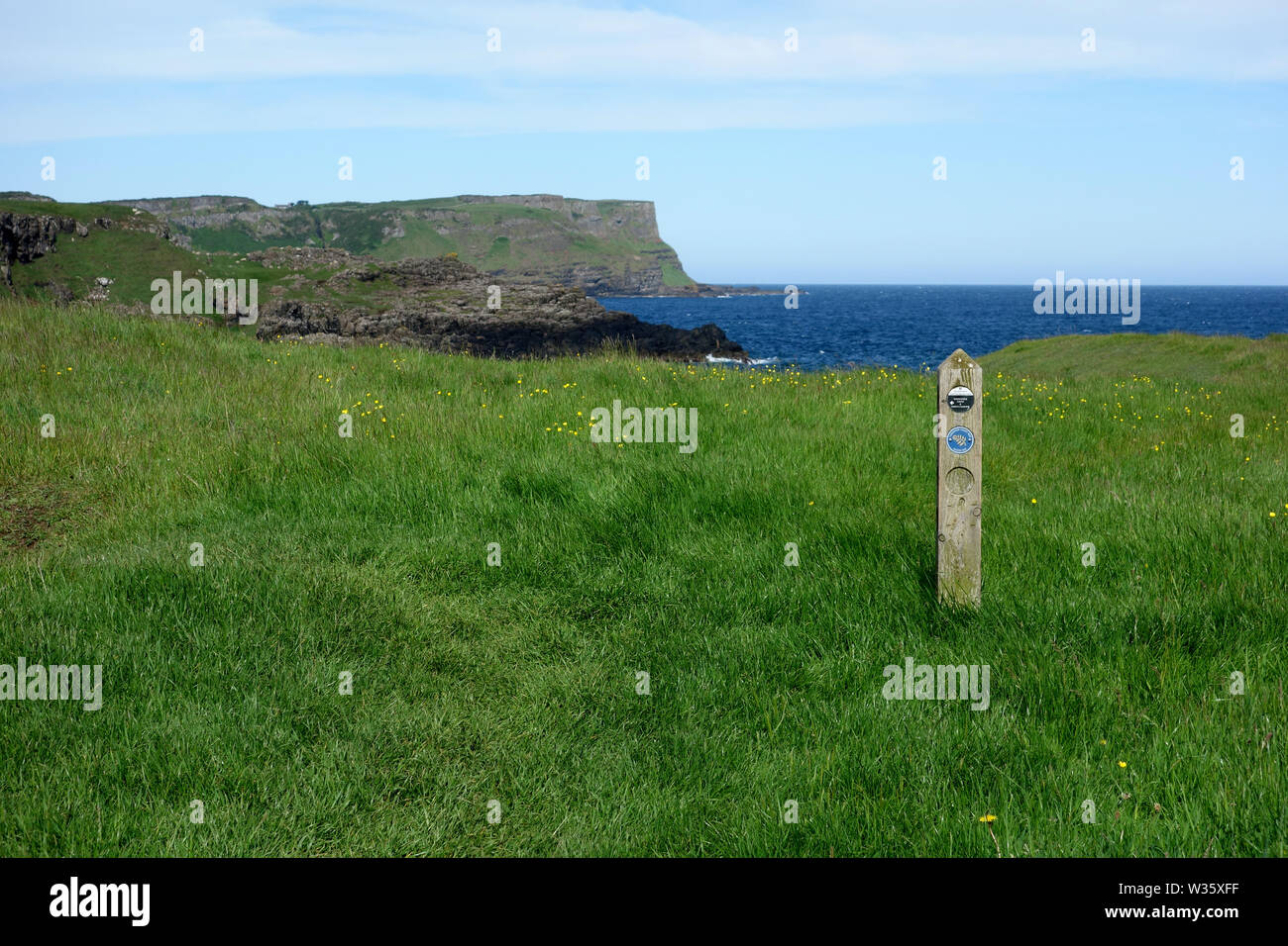 Wooden Signpost near Dunseverick Harbour with Benbane Head in the ...