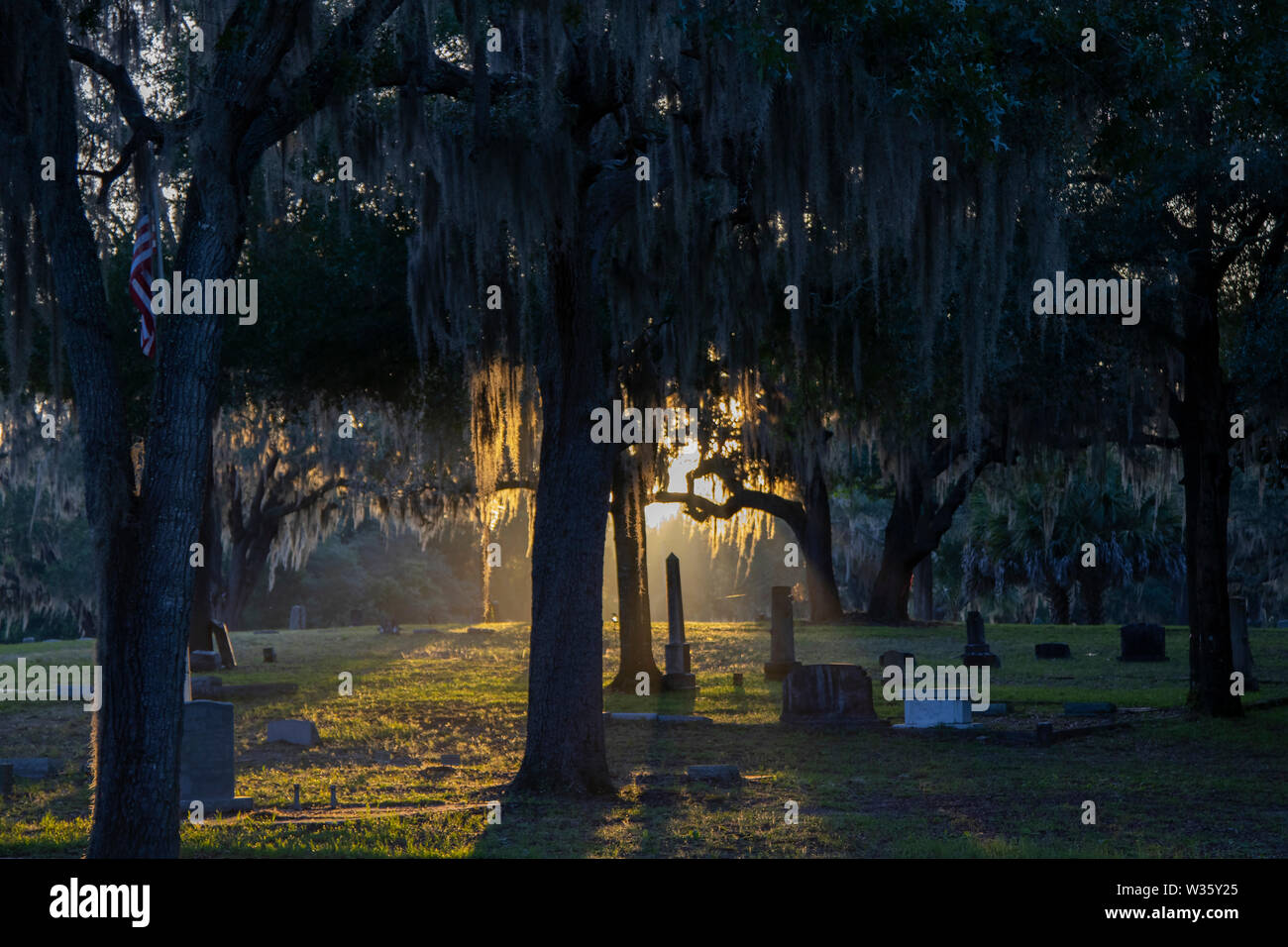 Dramatic sunset with tombstones and trees in a cemetery Stock Photo - Alamy