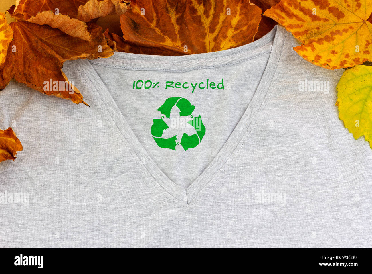Recycle clothes icon on t shirt with 100% Recycled text on autumn ...