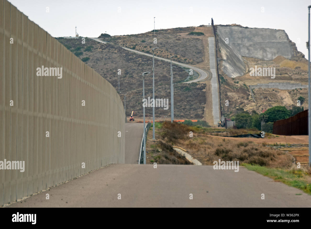 The San Diego secondary barrier (foreground left) and access road, with ...