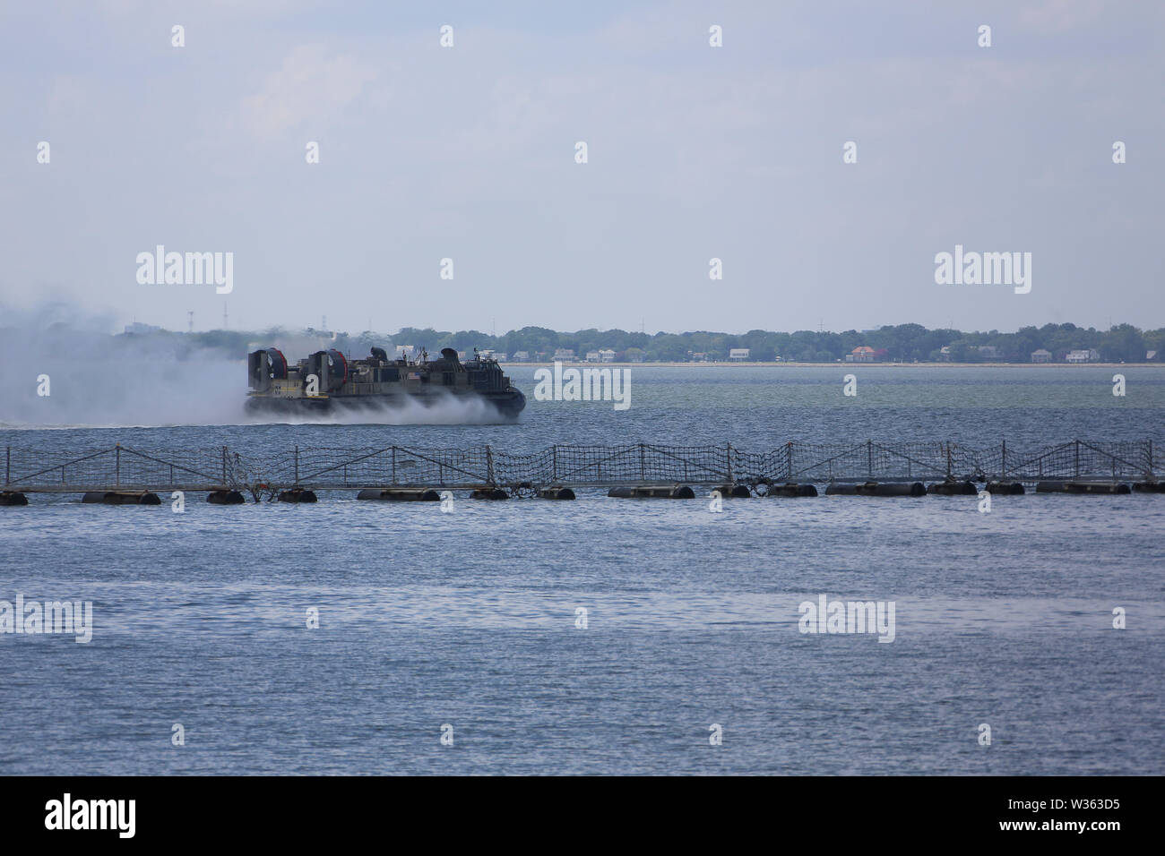 U.S. Navy Landing Craft, Air Cushion 84 (LCAC 84) departs the dock ...