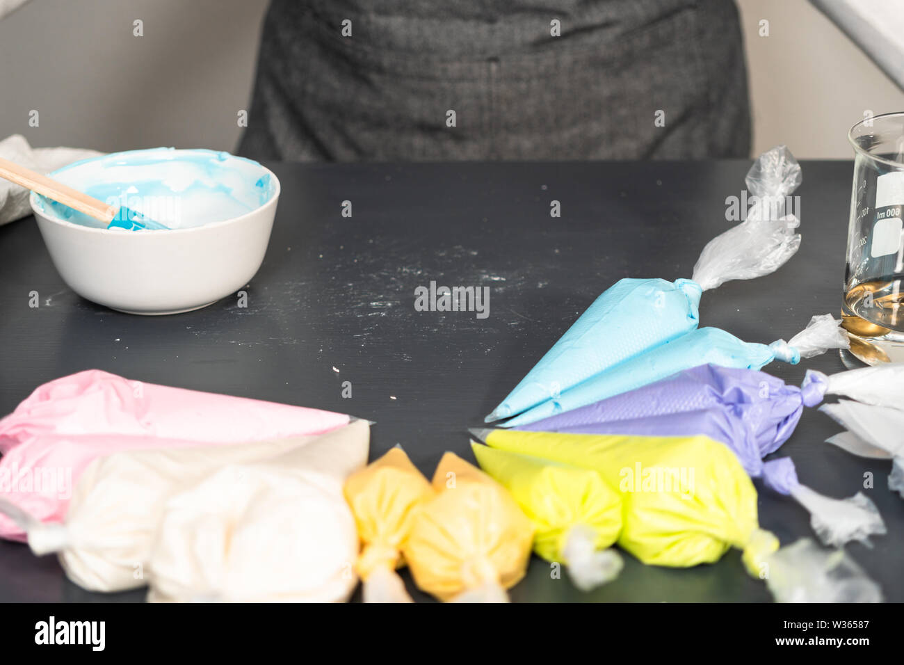 Mixing royal icing of different colors to decorate sugar cookies Stock ...