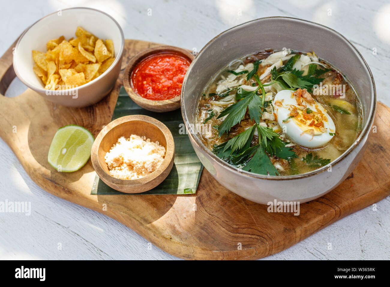 Soto ayam, a yellow spicy chicken soup with boiled egg, parsley and ...