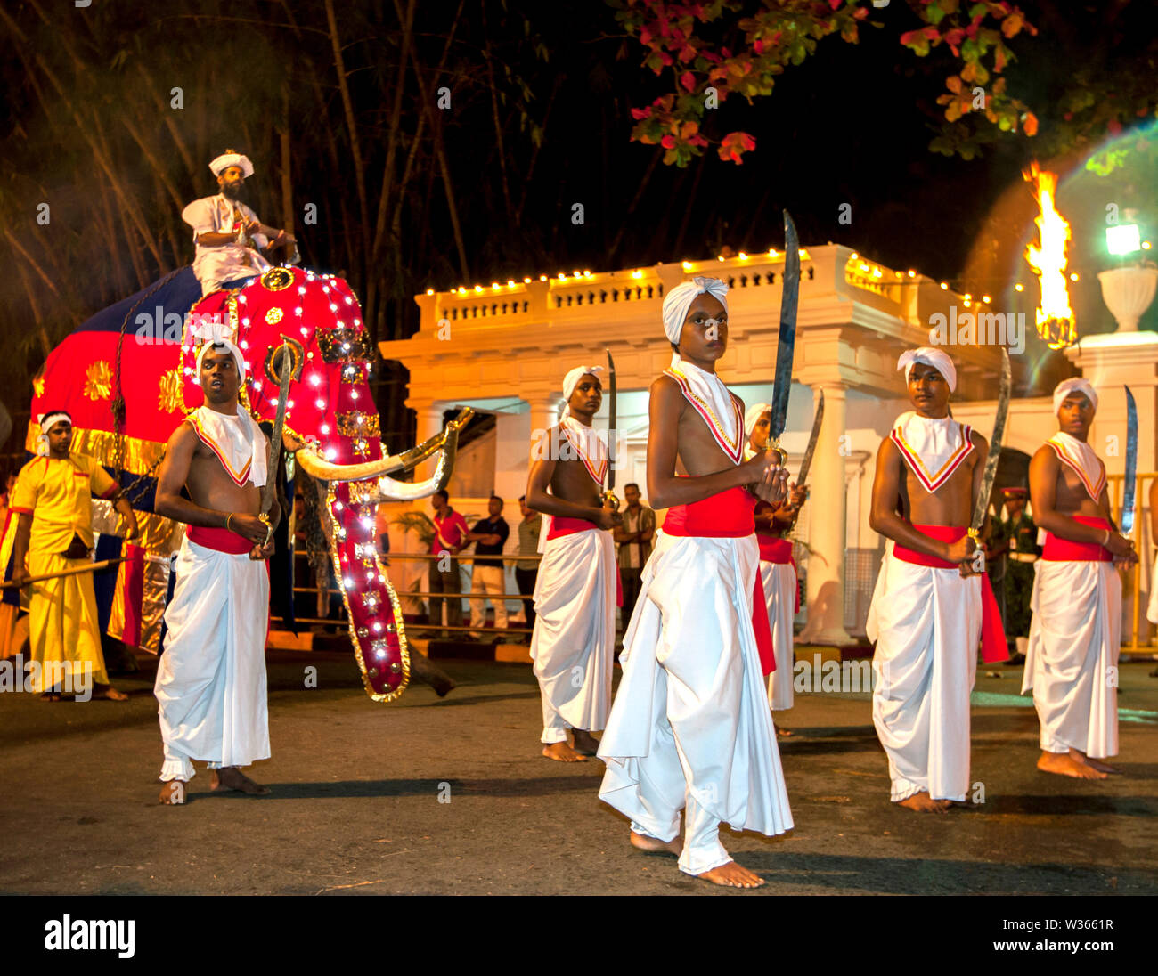Sword Carriers walk along the route of the Esala Perahara with swords ...