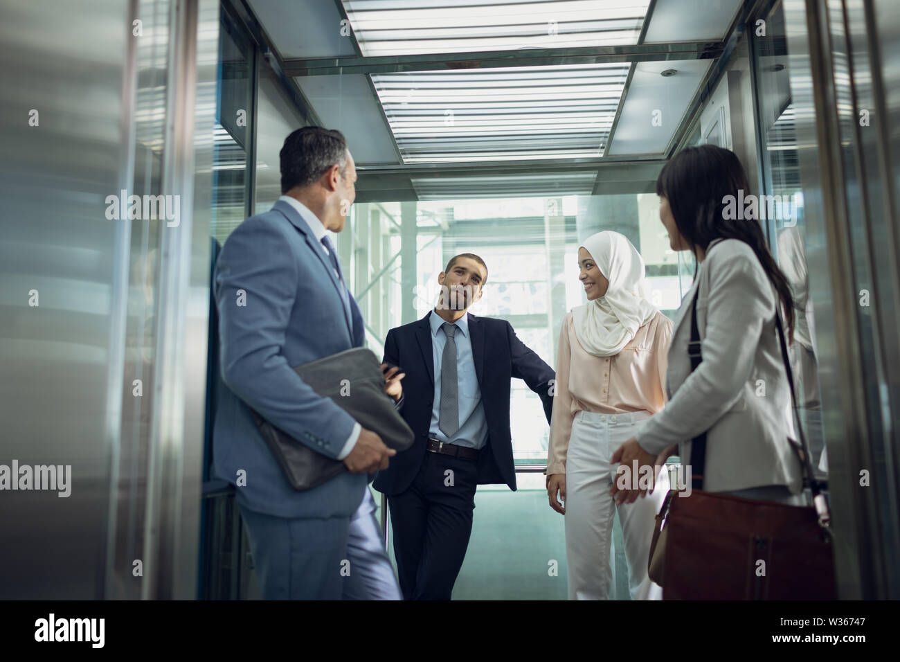 Diverse business people using lift in modern office Stock Photo - Alamy