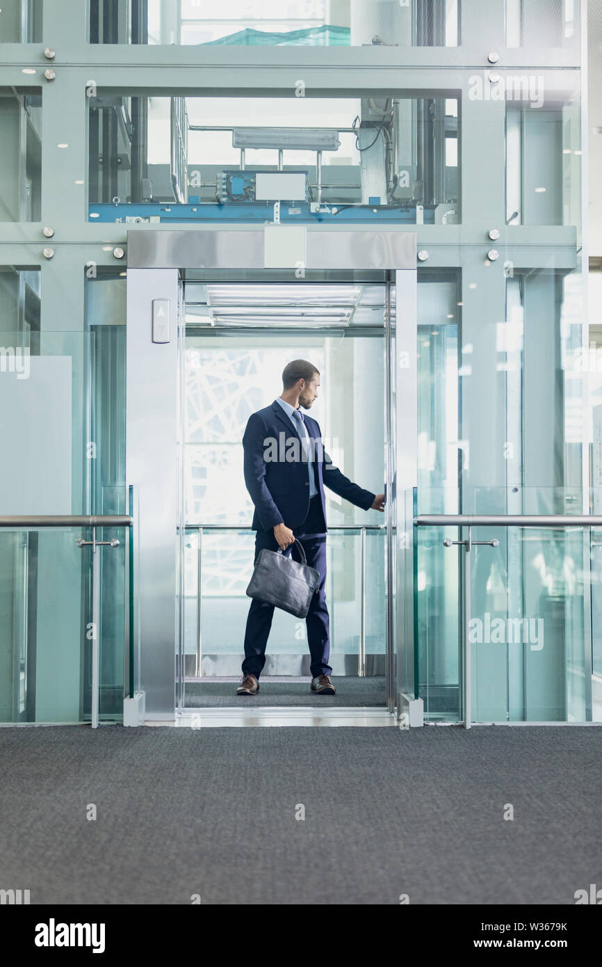 Male executive taking the lift in modern office Stock Photo - Alamy