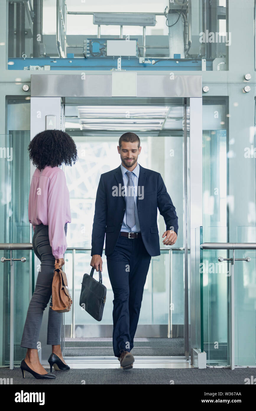 Male executive exiting the lift in modern office. African american ...