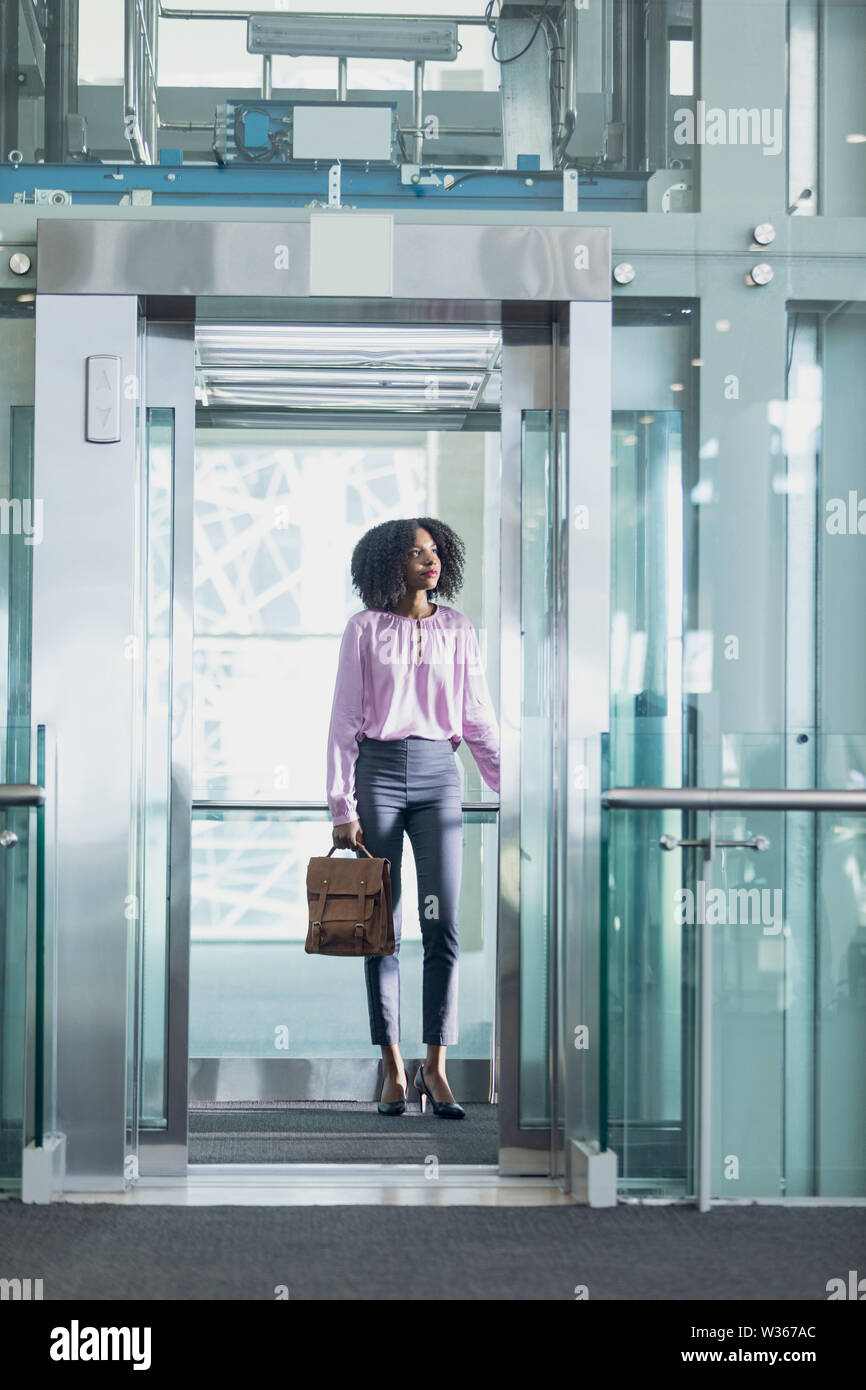 Female executive taking the lift in modern office Stock Photo - Alamy