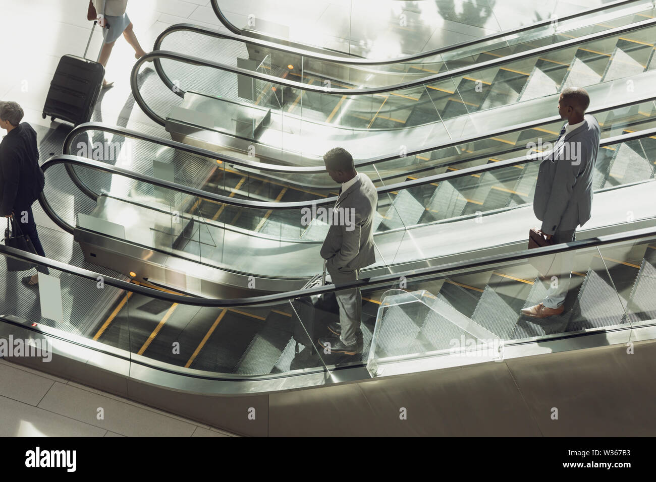 Business people using escalators in modern office Stock Photo - Alamy