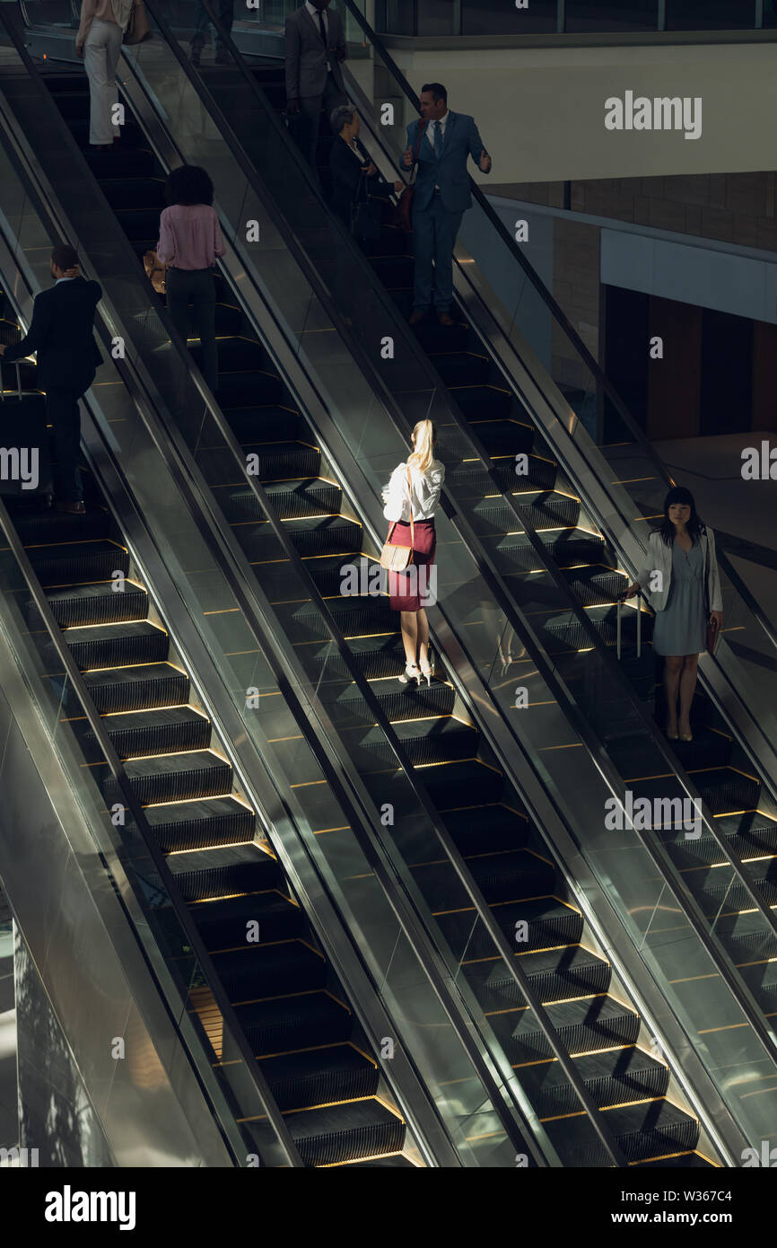 Business people using escalators in modern office Stock Photo - Alamy
