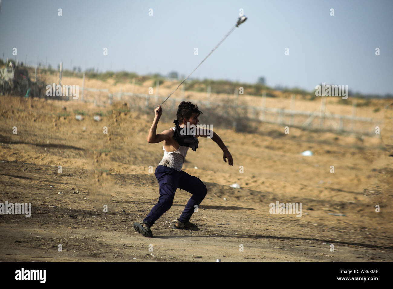 Gaza, Palestine. 12th July, 2019. A Palestinian demonstrator uses a ...