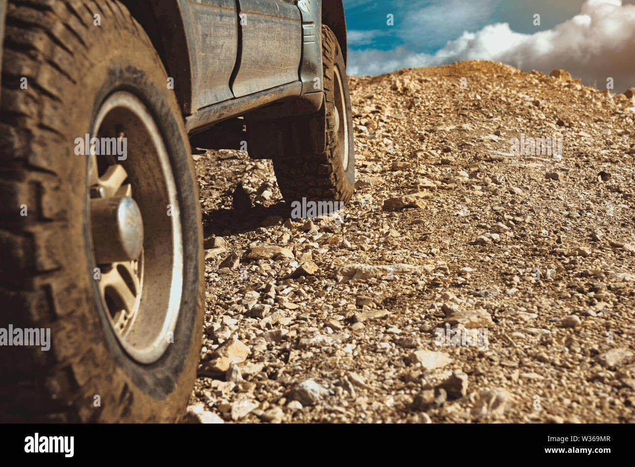 Closeup photo of all-terrain car wheels in mountains area. Off-road 4x4 ...