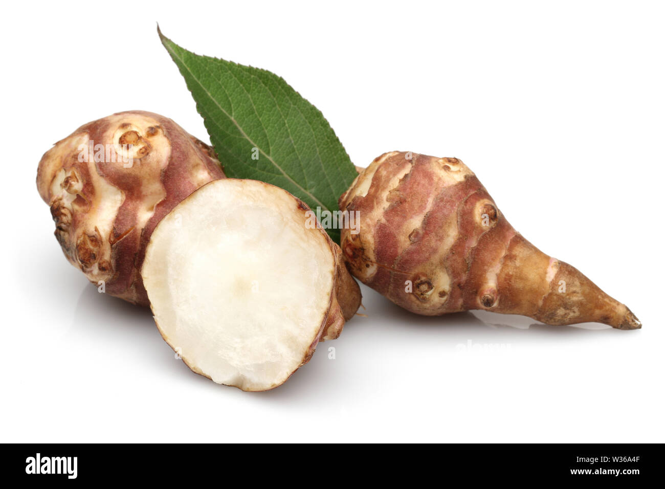 Jerusalem artichoke or sweet potato with slices and leaf isolated on ...