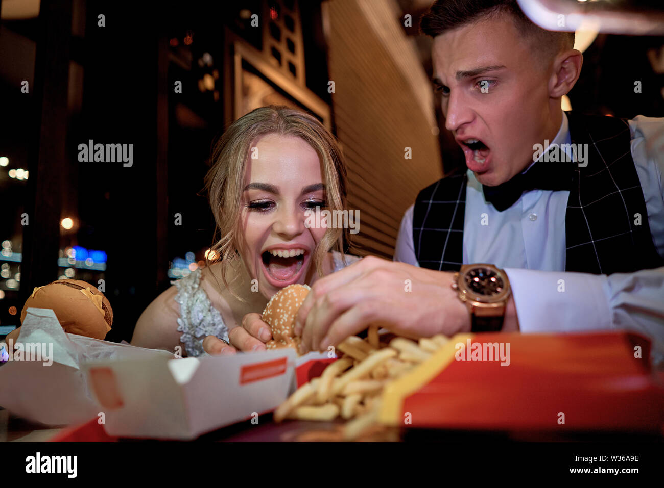 Young couple eating burgers hi-res stock photography and images - Alamy