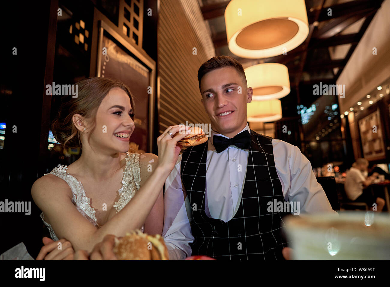 couple eating burgers Stock Photo - Alamy