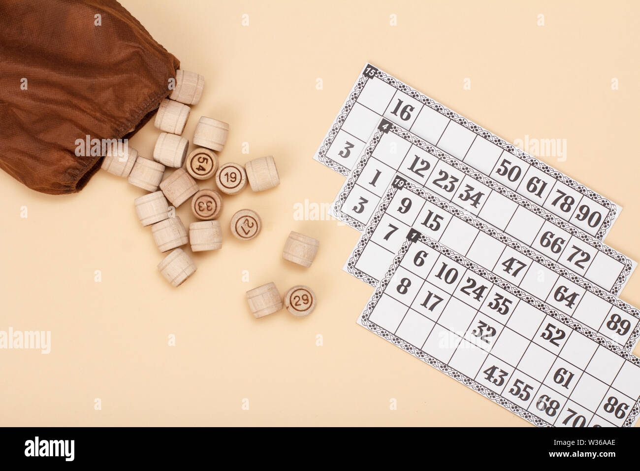 Wooden lotto barrels with open bag and game cards on beige background ...