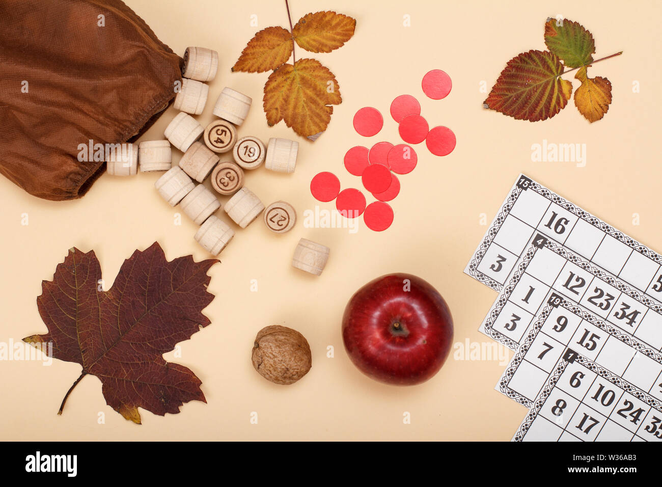 Wooden lotto barrels with open bag, dry autumn leaf, apple, walnut ...