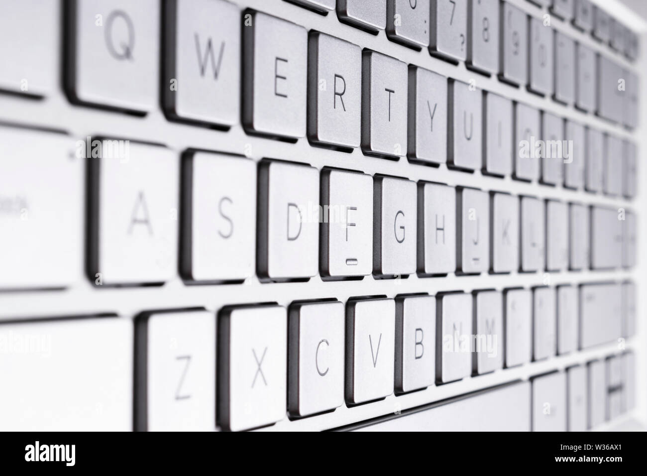 Closeup of a modern silver laptop computer keyboard. Laptop keyboard ...