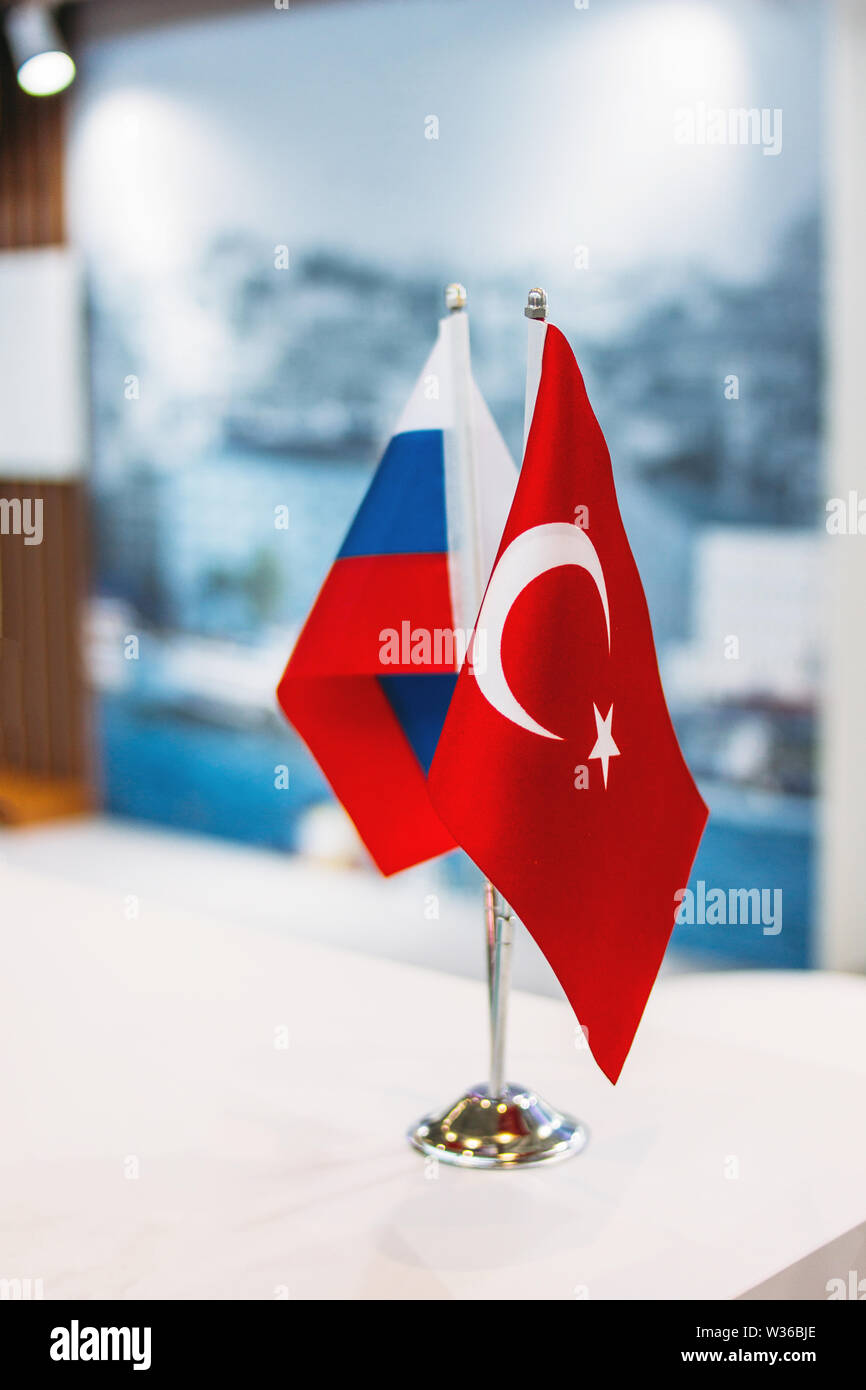 Russian and Turkish flags on metal stand on the business conference or ...