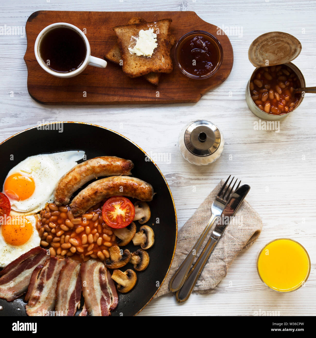 Full English breakfast in a pan with fried eggs, bacon, beans, sausages ...